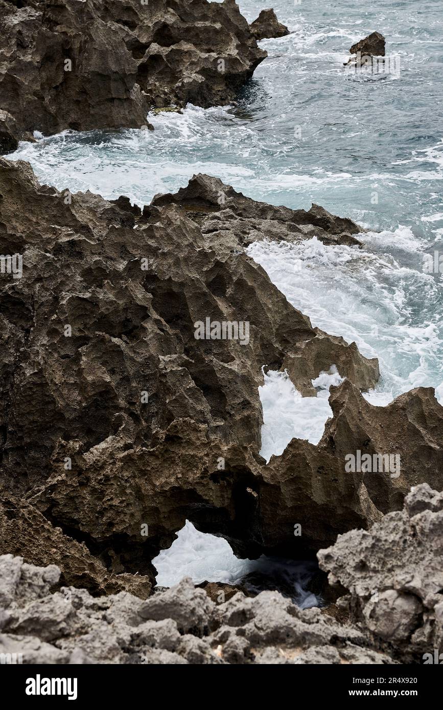Waves breaking on the shore on a pebble road. water foam, wild waters ...