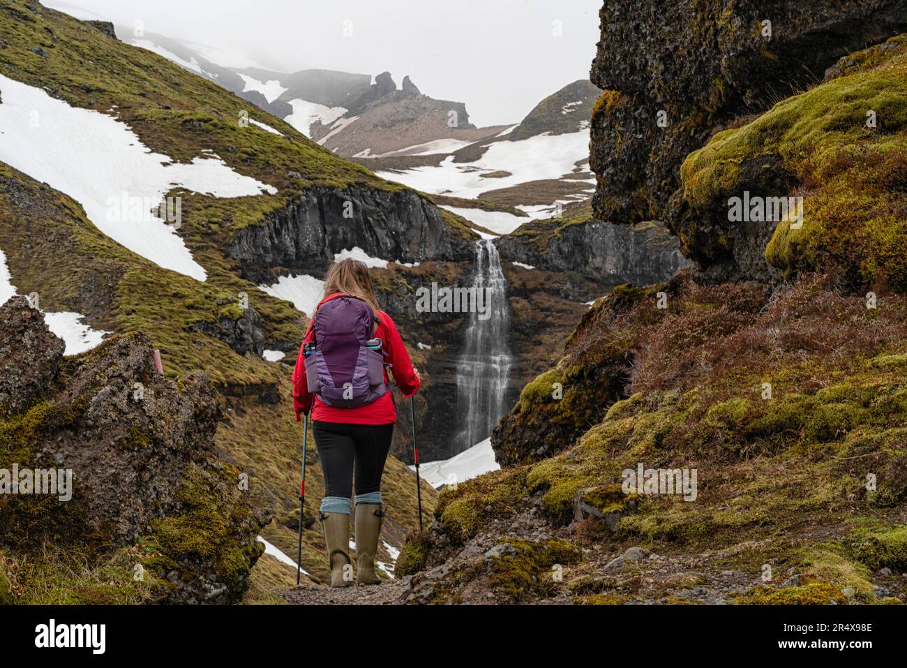 Close-up view, taken from behind, of a woman standing and overlooking ...