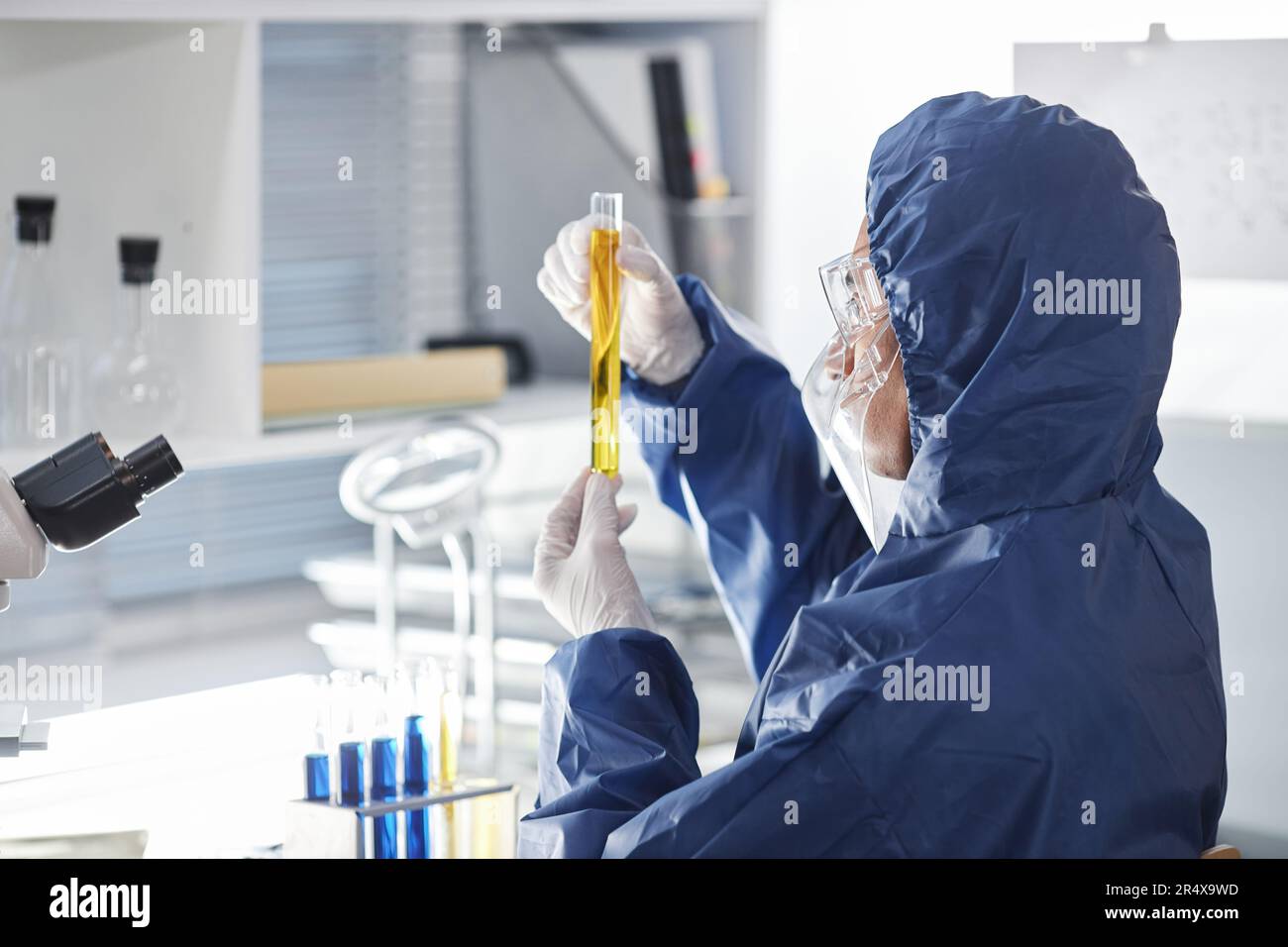 Side view of scientist wearing protective suit working with hazardous ...