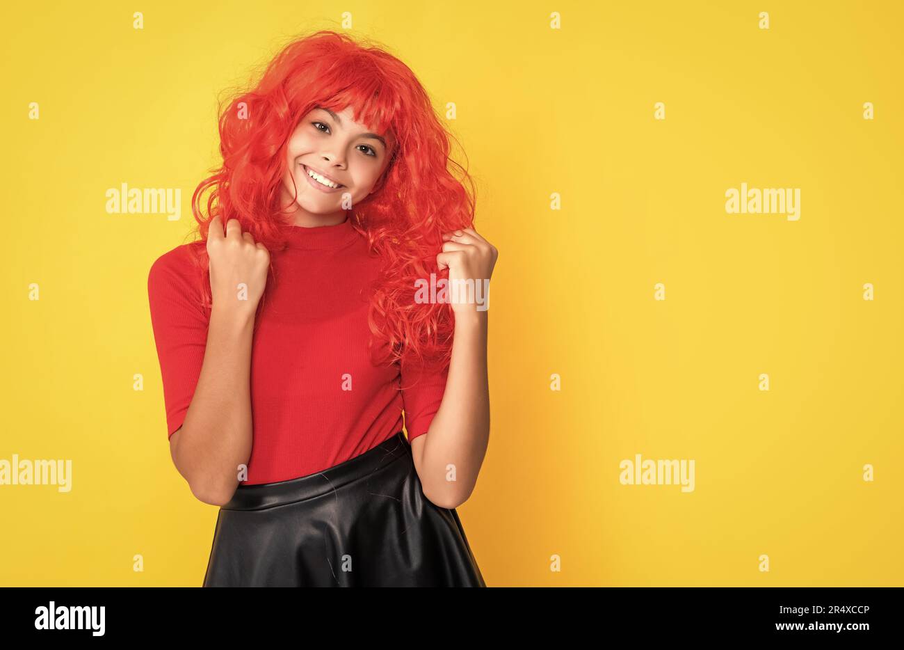 glad child with red long hair on yellow background Stock Photo - Alamy