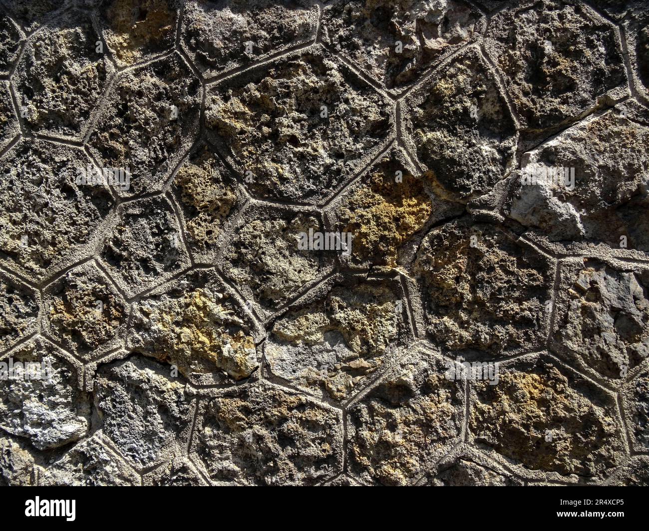 Hard light showing the strong textures in a stone wall and pointing ...