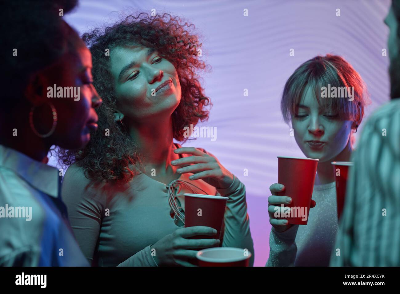 Waist up portrait of pretty young girls dancing at house party and ...