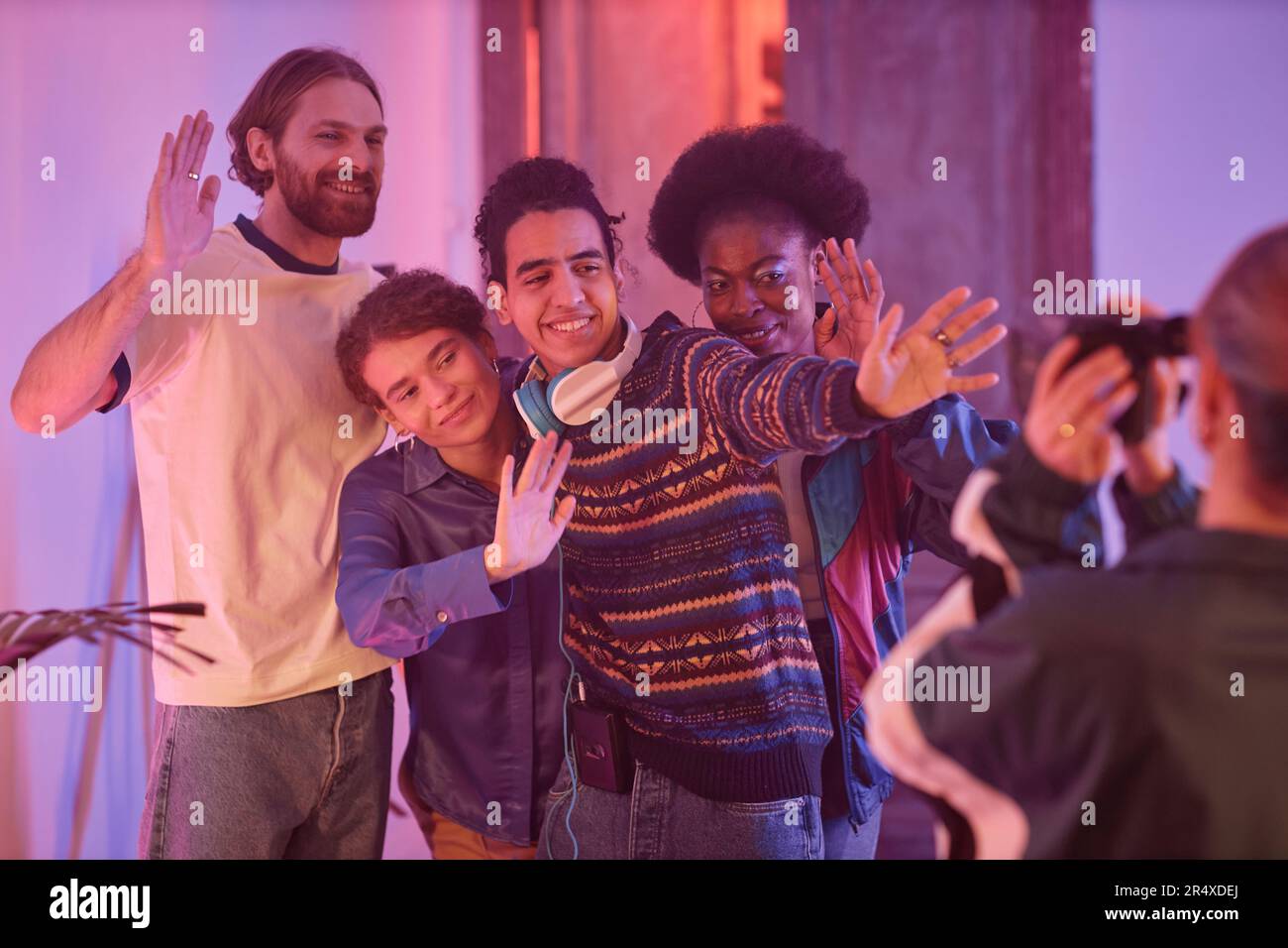Diverse group of friends having fun at house party with woman holding ...