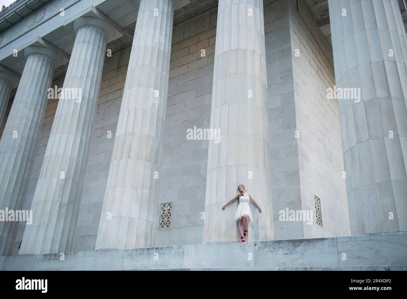 Teenage girl standing against a large column at the Lincoln Memorial in ...