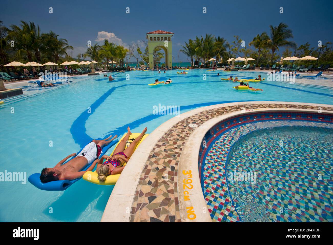 Vacationers relax as they float in a large swimming pool in the ...