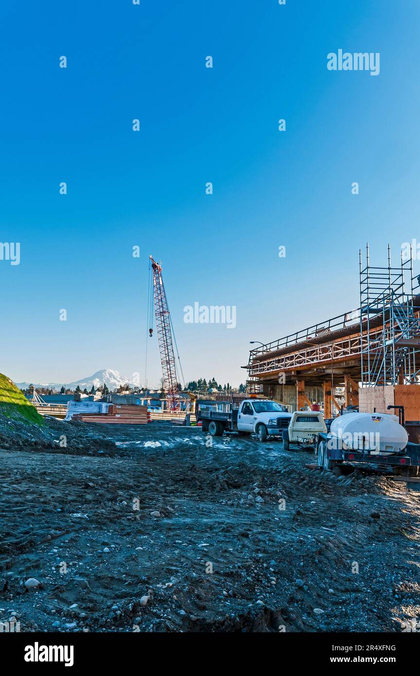 A highway ramp construction site with a crane, electrical generator ...