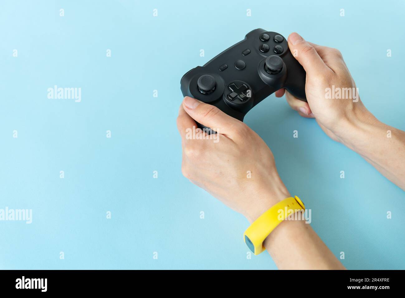 Isolated hands on a blue background that hold a joystick. Young gamer ...