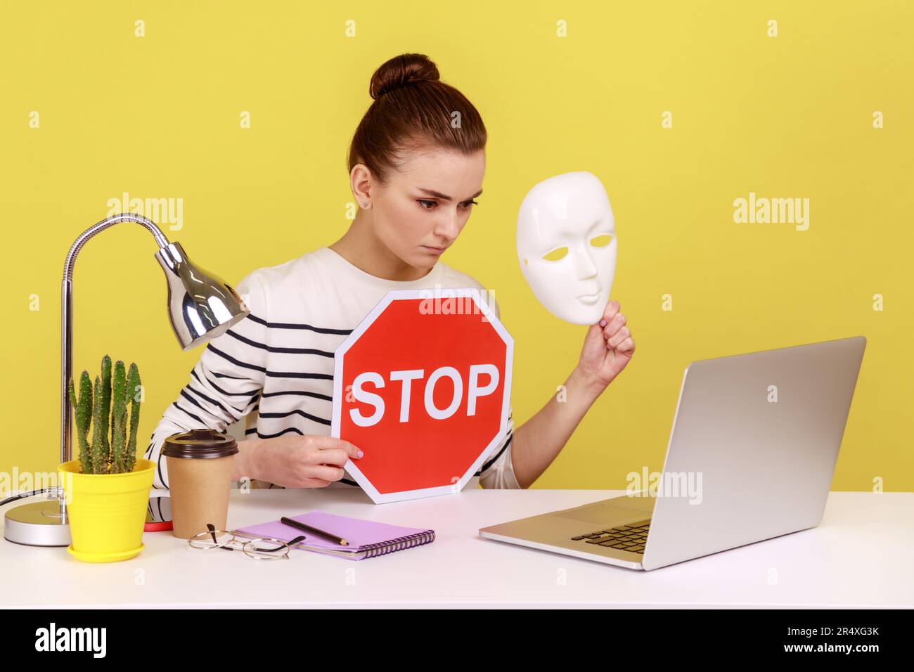Portrait of serious young adult woman holding white mask with unknown ...