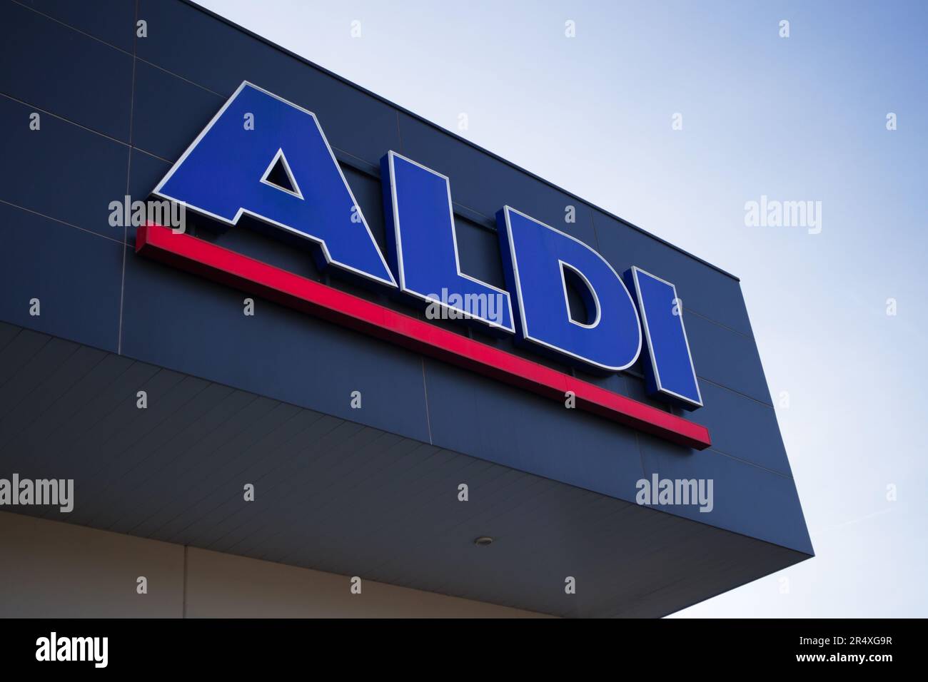 2023. Valencia, Spain. Aldi supermarket logo on one of its stores with blue sky in the ...