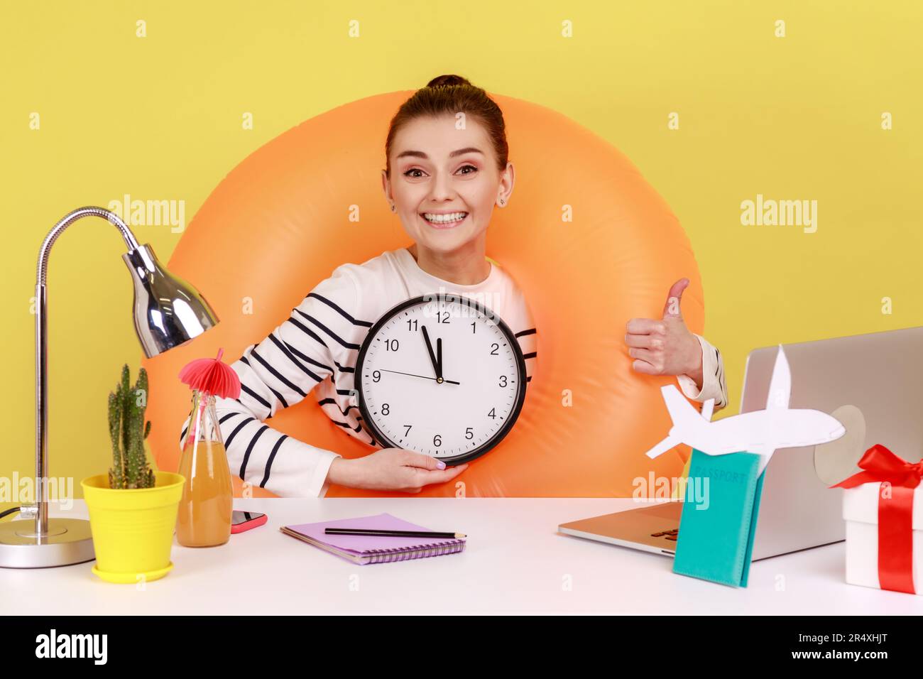 Happy excited woman in rubber ring on neck sitting at workplace with ...