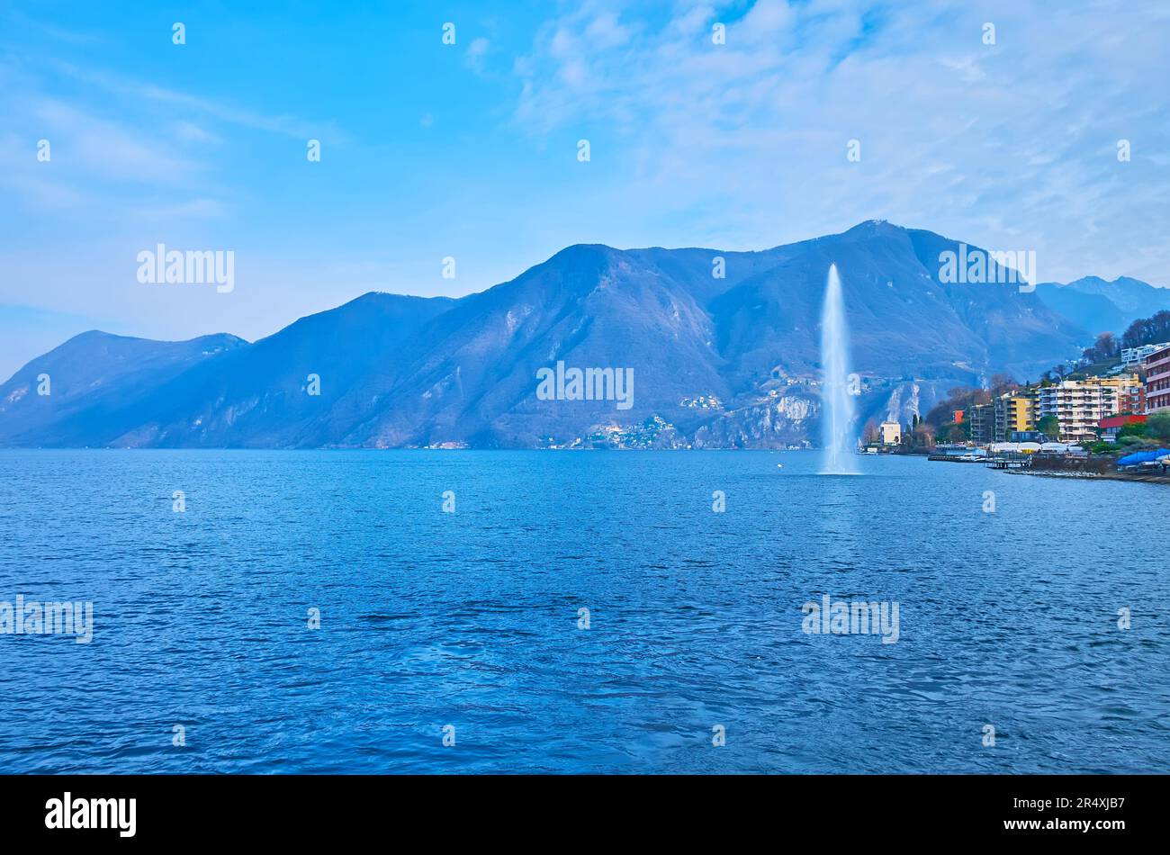 The mountain landscape behind the blue Lake Lugano and Water Jet of ...