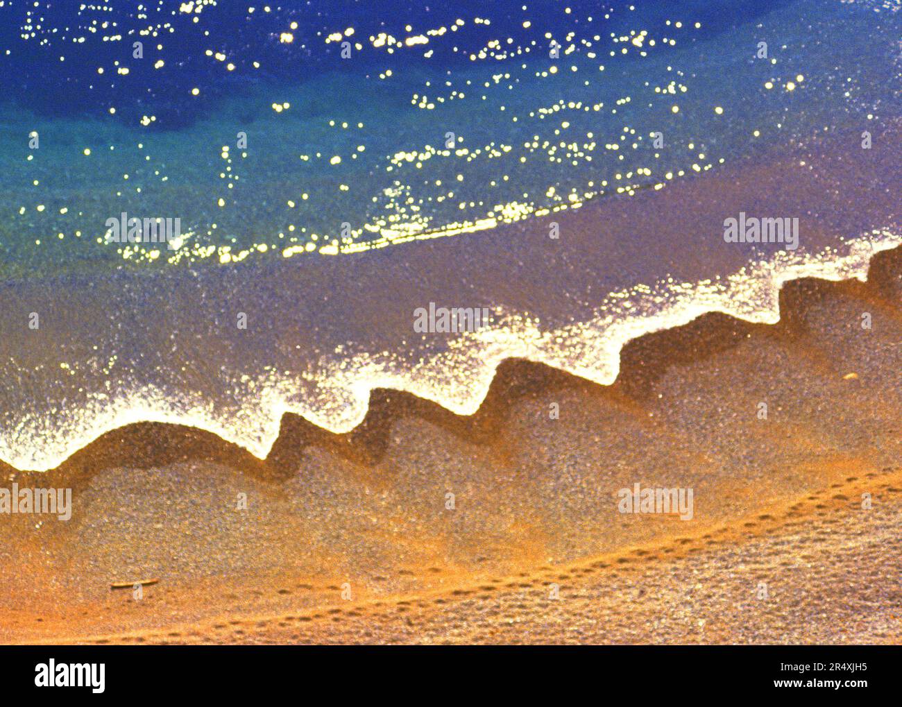 Abstract view of waves breaking on the sand and shingle beach near ...