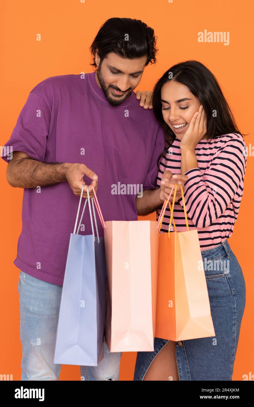 Beautiful young indian couple customers shopping together, checking ...