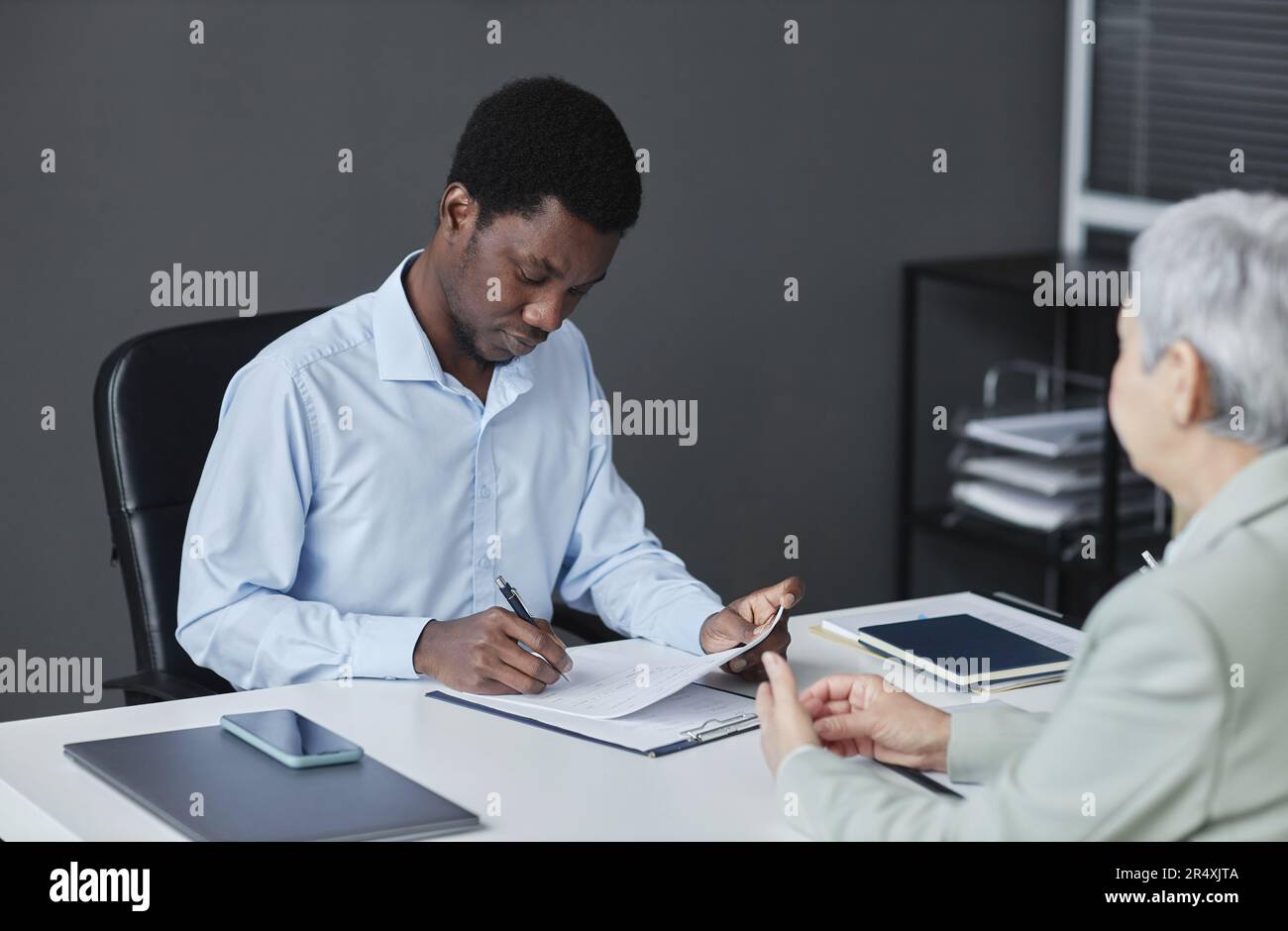Portrait of black businessman as HR recruiter reviewing CV in job ...