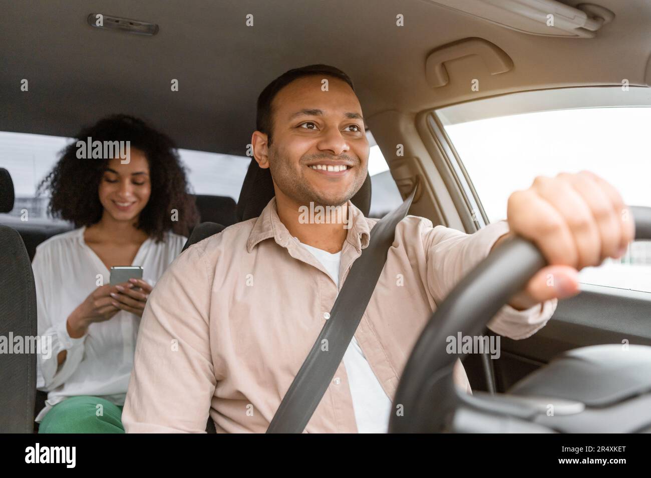 Taxi Driver Navigating Car While Passenger Using Smartphone On Backseat ... Taxi Driver Navigating Car While Passenger Using Smartphone On Backseat ...