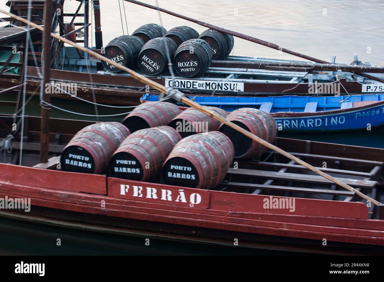 Boats carrying wine barrels docked alongside the Douro River in Porto ...