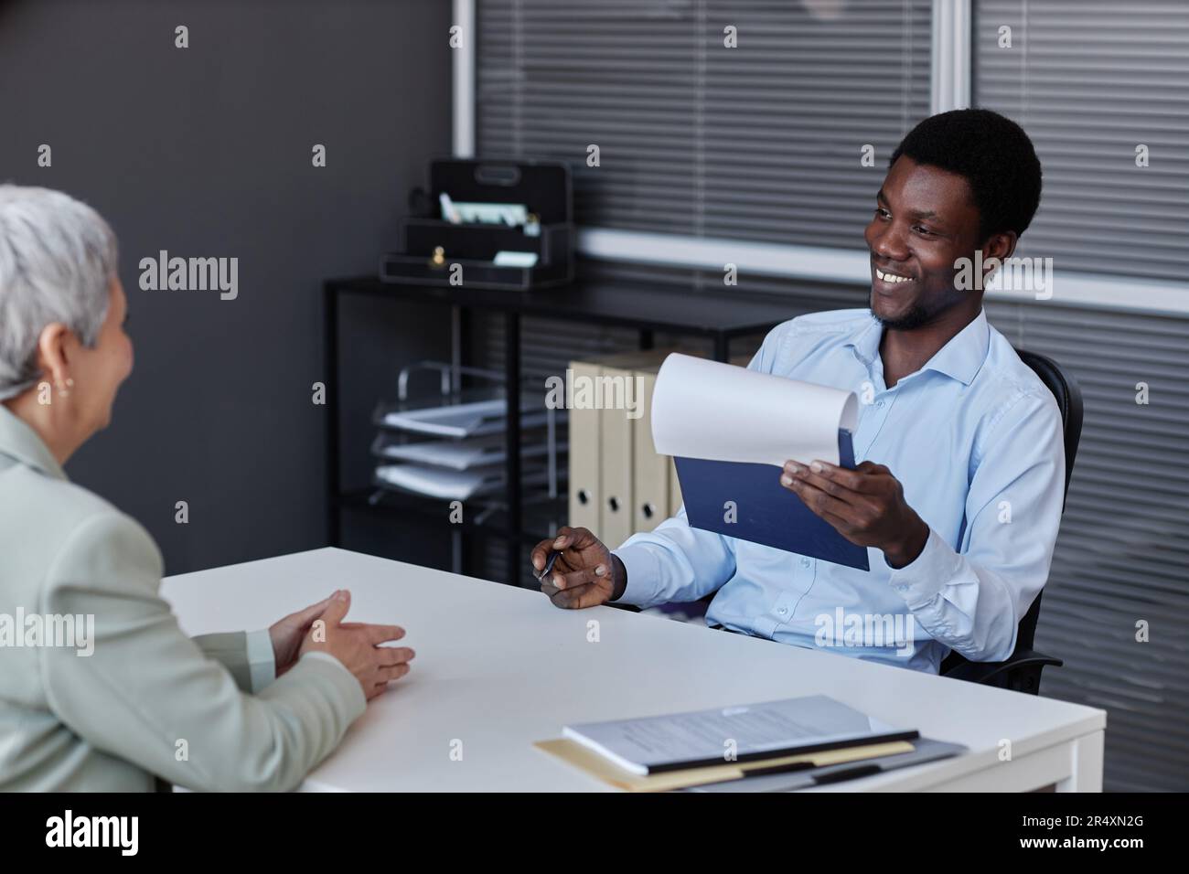 Portrait of smiling black man as HR recruiter talking to senior ...