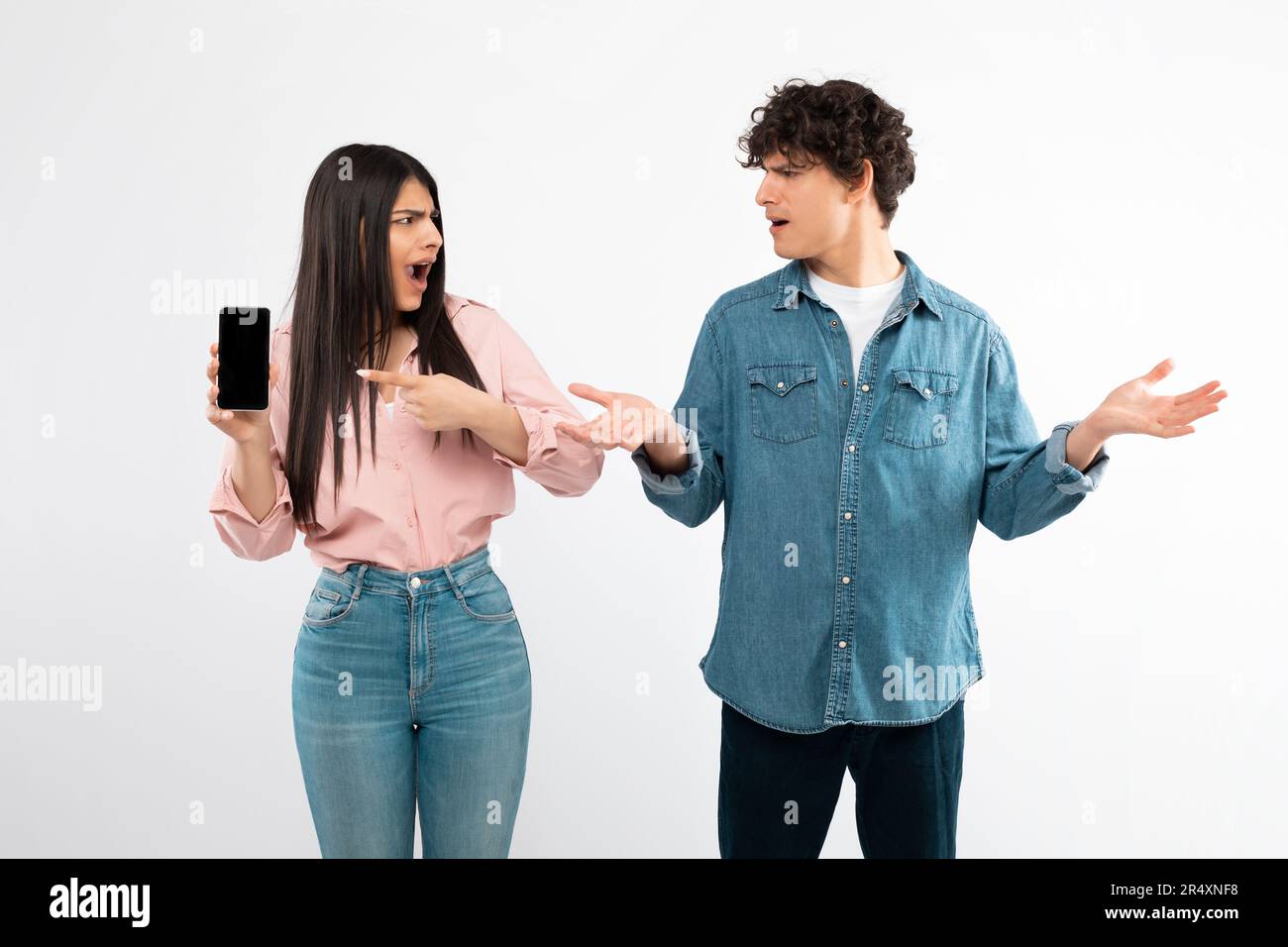 Angry Girlfriend Showing Phone Screen To Confused Boyfriend, White ...