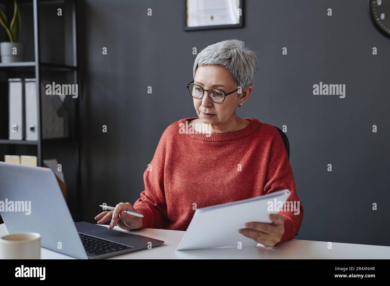 Portrait of successful senior woman as female boss using computer at ...