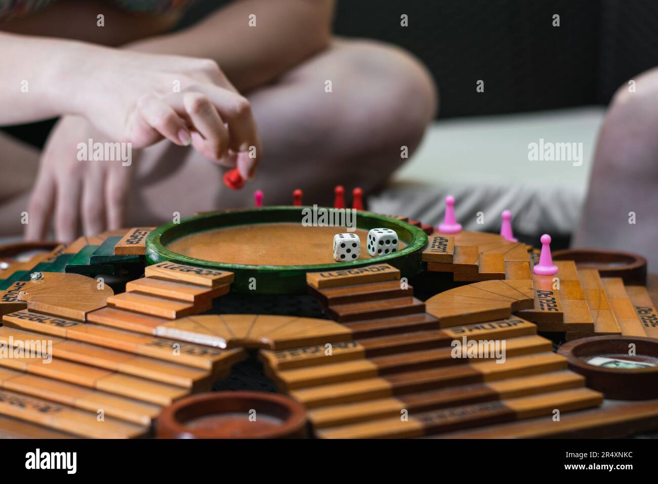 close-up of the hand of a girl who is holding the token of the board ...
