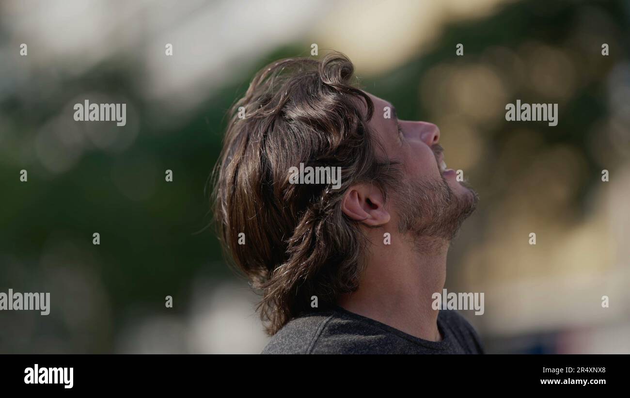 One happy young man looking up at sky with HOPE and FAITH. Smiling male ...