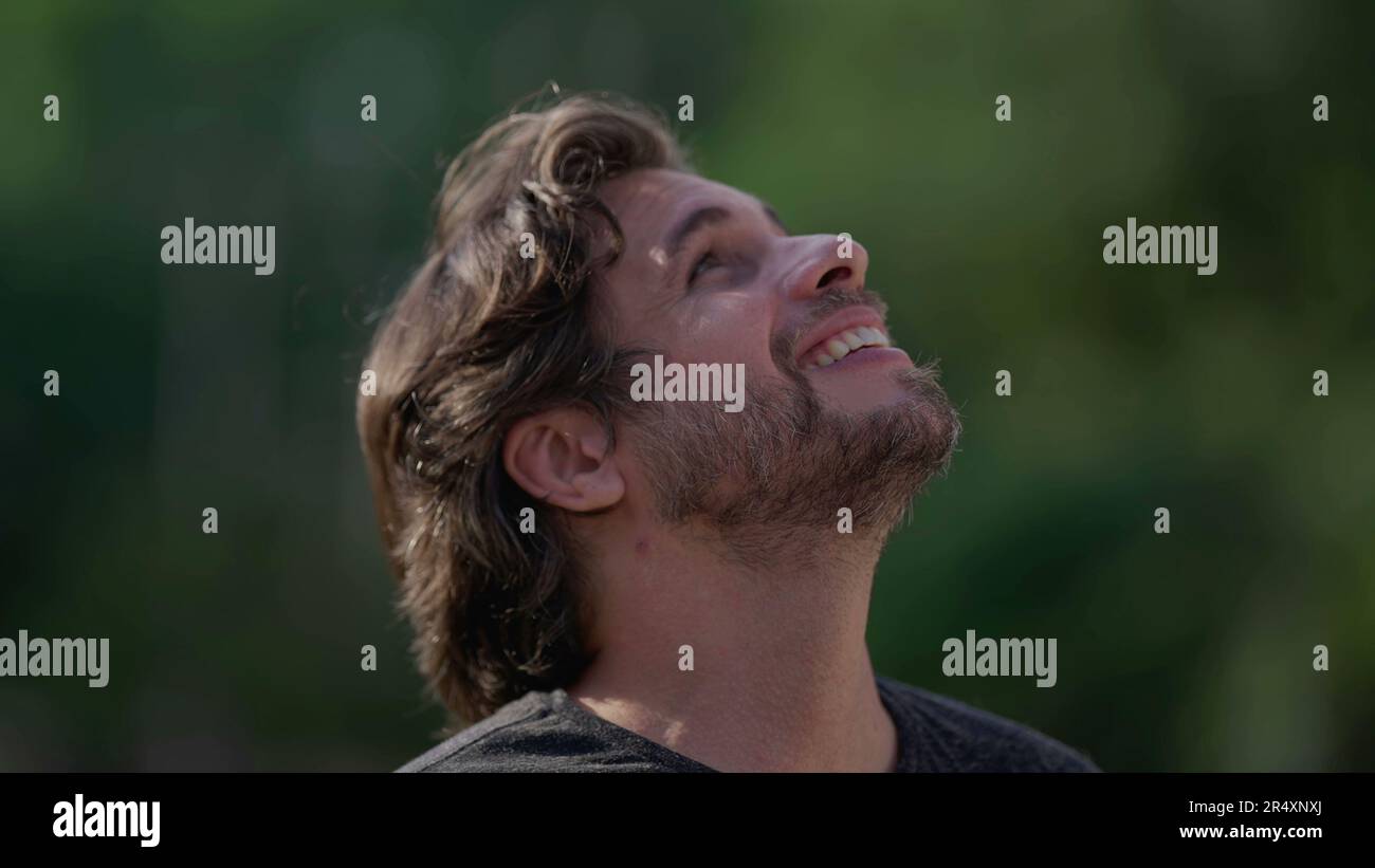 One happy young man looking up at sky with HOPE and FAITH. Smiling male ...