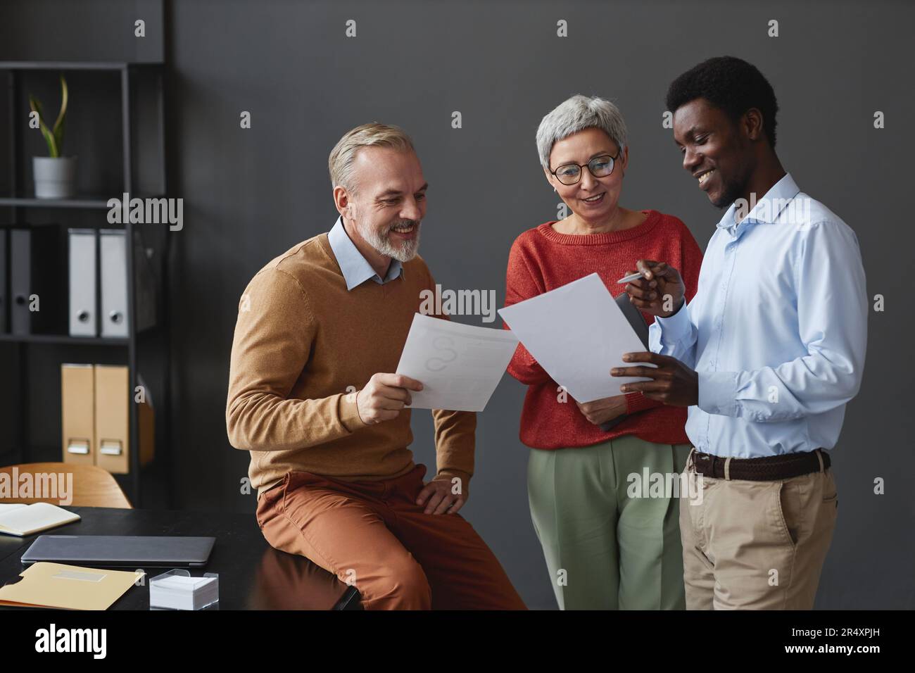Diverse group of business people with senior workers collaborating on project in office Stock ...