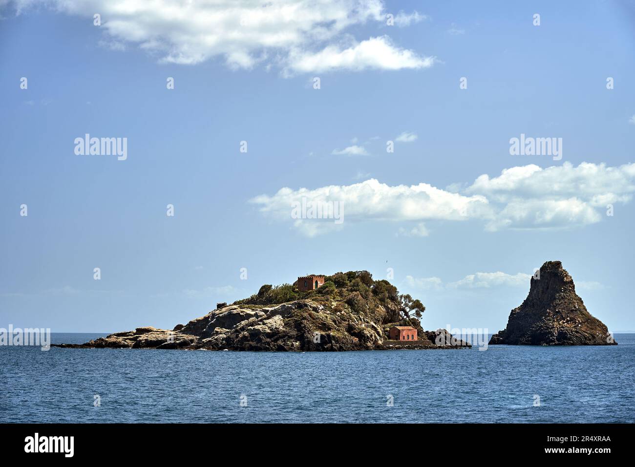 Rocky islet with historic buildings on the Cyclops coast in Sicily ...