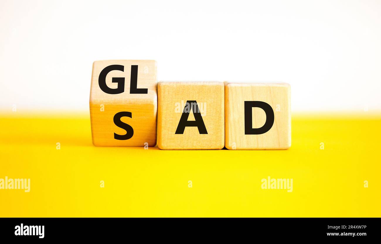 Glad or sad symbol. Businessman turns wooden cubes and changes the word ...