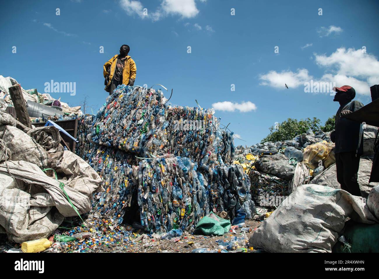 A worker arranges bales of plastic at a recycling plant in Nakuru ...