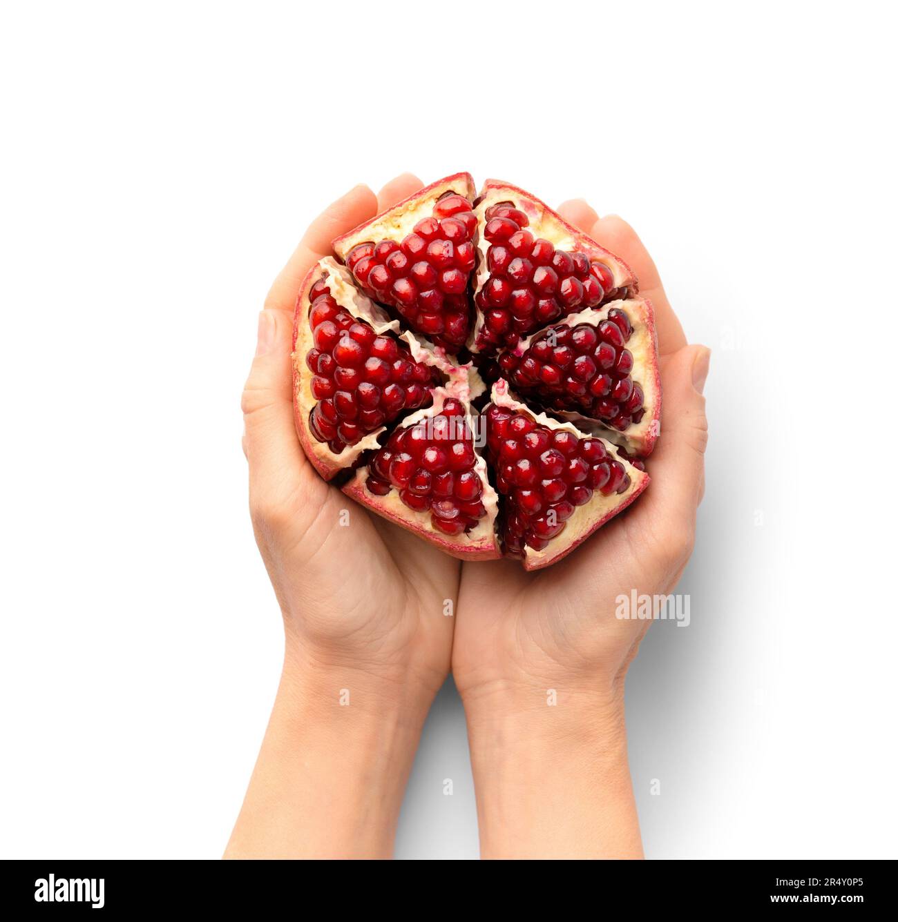 Ripe peeled pomegranate in hands on a white background top view. A ...