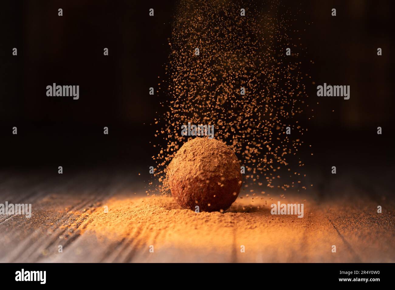 Cocoa powder is sprinkled on a chocolate truffle under a beautiful ...