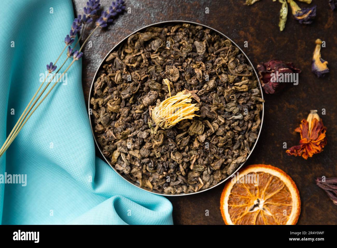 Composition of green, flower tea and dried orange slices on blue and ...