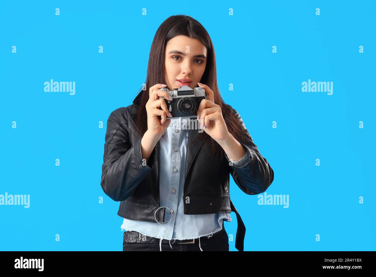 Beautiful female photographer with vintage camera on light blue ...