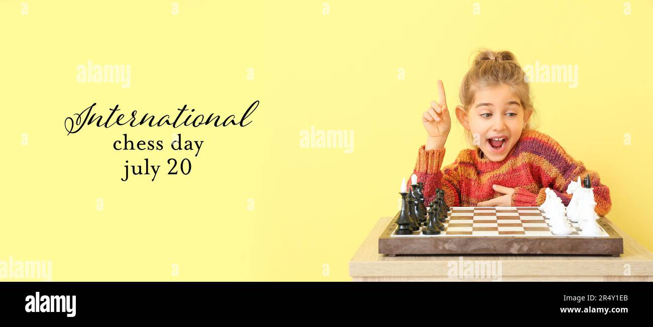 Cute little girl playing chess on yellow background. International ...