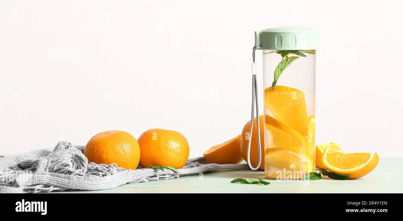 Bottle of orange infused water on light background Stock Photo - Alamy