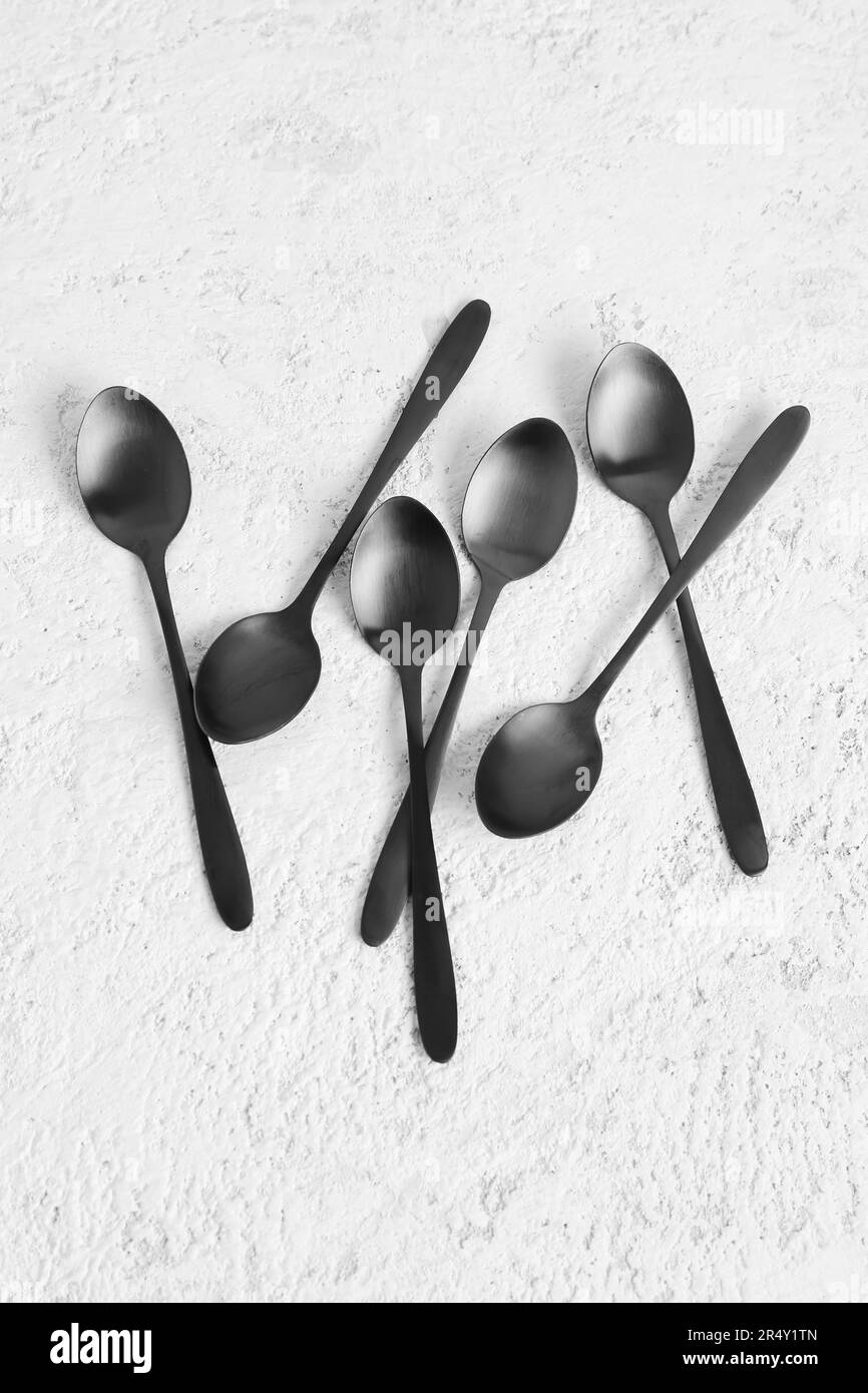 Stainless steel spoons on white background Stock Photo - Alamy
