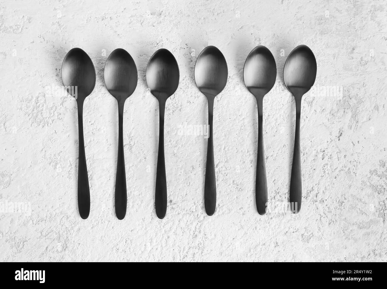 Stainless steel spoons on white background Stock Photo - Alamy