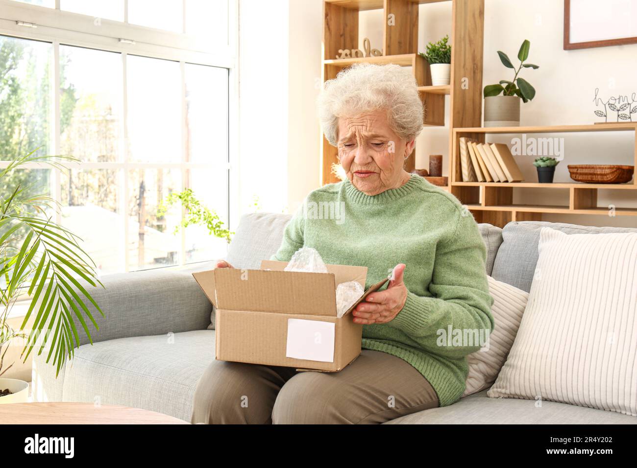 Senior woman opening parcel box hi-res stock photography and images - Alamy