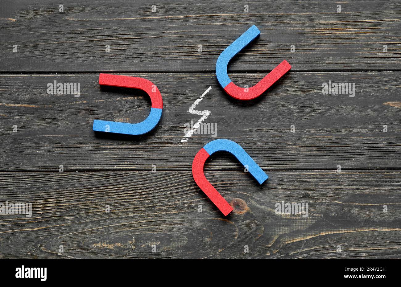 Frame made of magnets with drawn lightning on dark wooden background ...