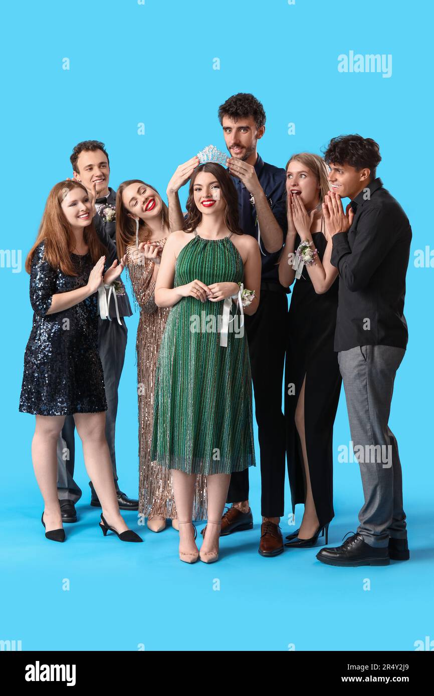 Young people crowning prom queen on blue background Stock Photo - Alamy