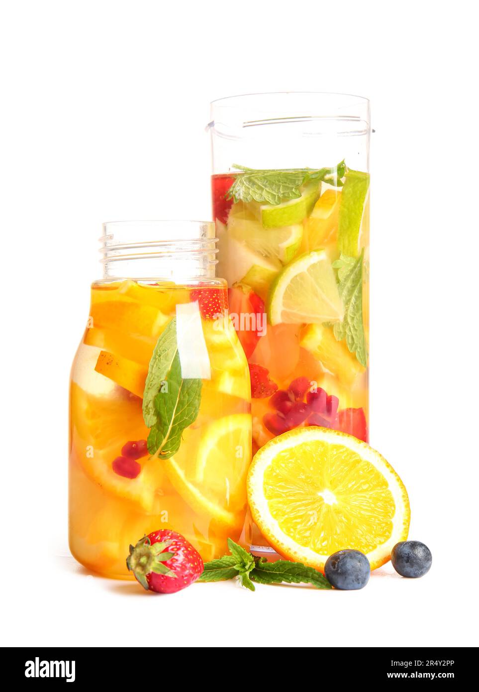 Bottles of infused water with different sliced fruits on white ...