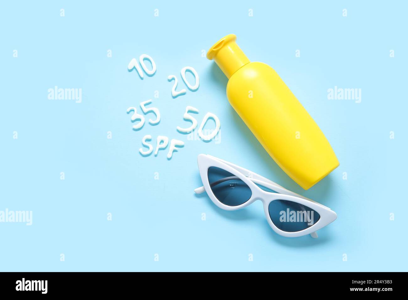 Word SPF with numbers made of sunscreen cream and sunglasses on blue ...