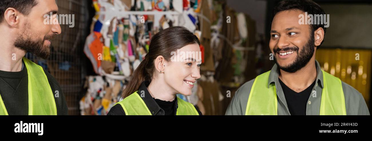 Positive young woman in high visibility vest looking away while ...