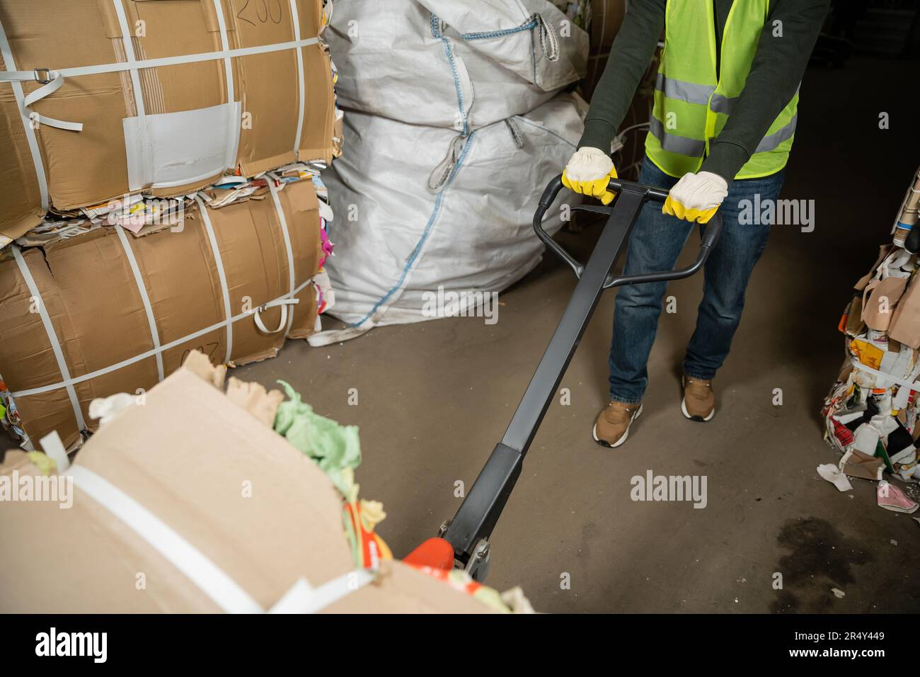 Cropped view of sorter in high visibility vest and gloves using hand ...