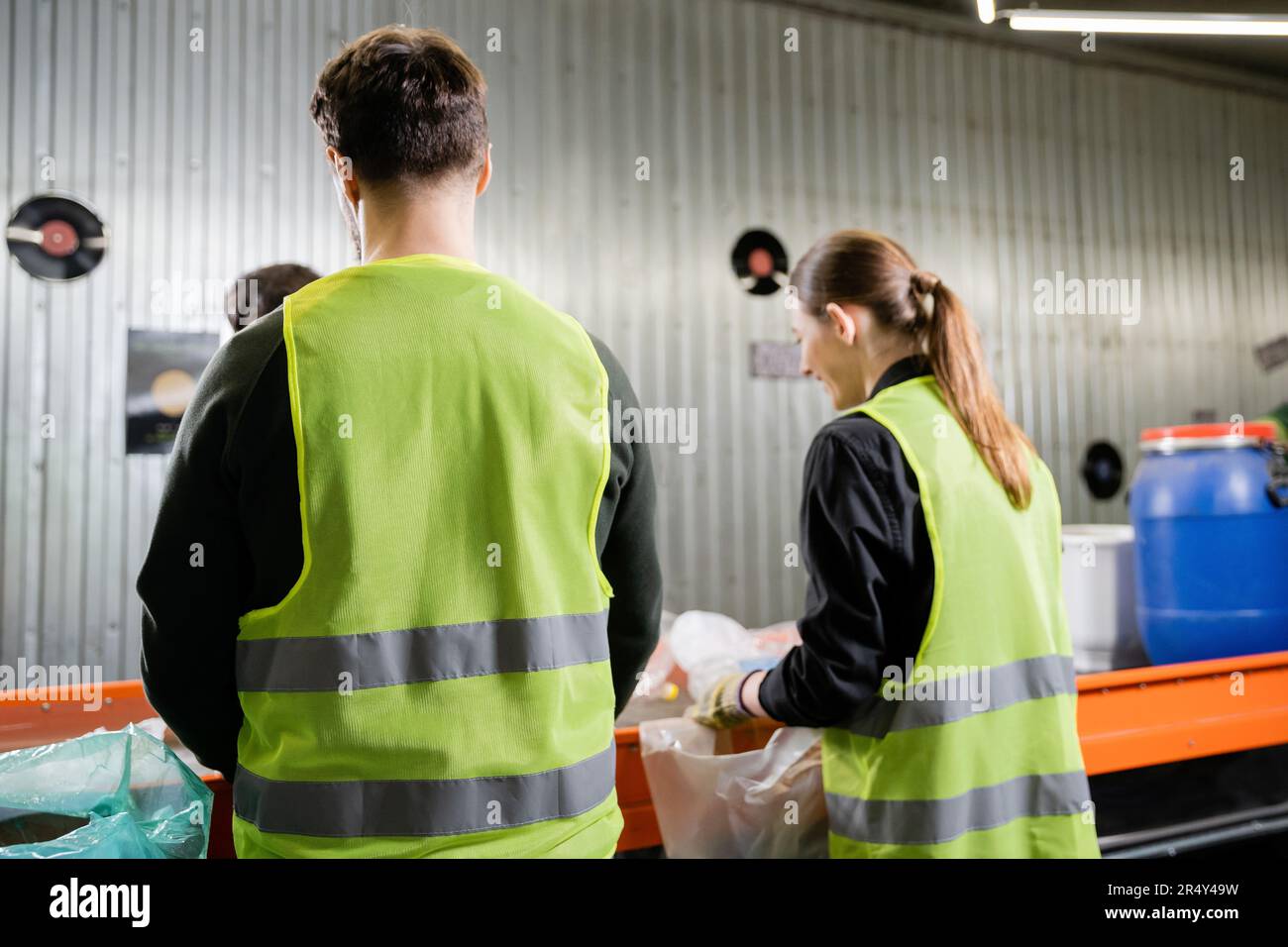 Worker in protective high visibility vest uniform separating trash near ...