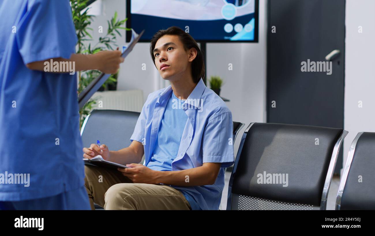Nurse helping patient to fill document Stock Photo - Alamy