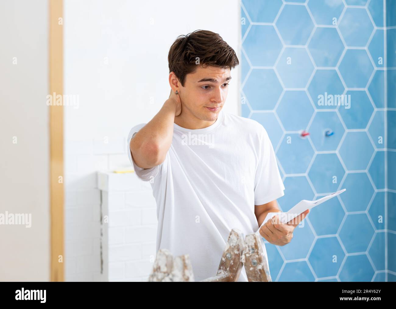 Confused young designer determining scope of work in apartment during ...
