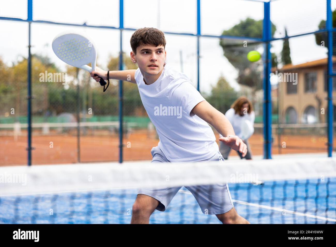 Sporty young guy playing padel on open court Stock Photo - Alamy