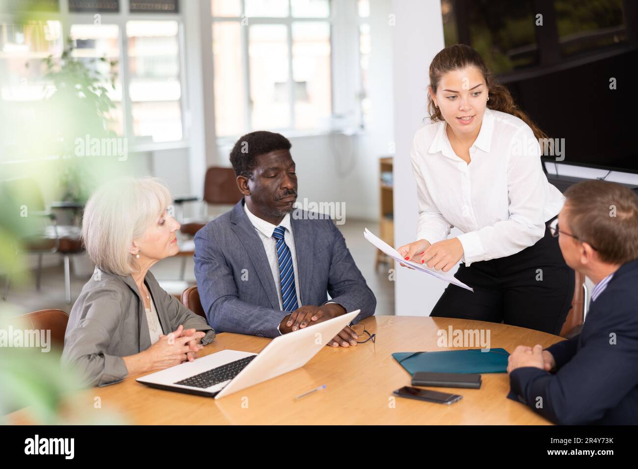Group of different people arguing at table in office Stock Photo - Alamy